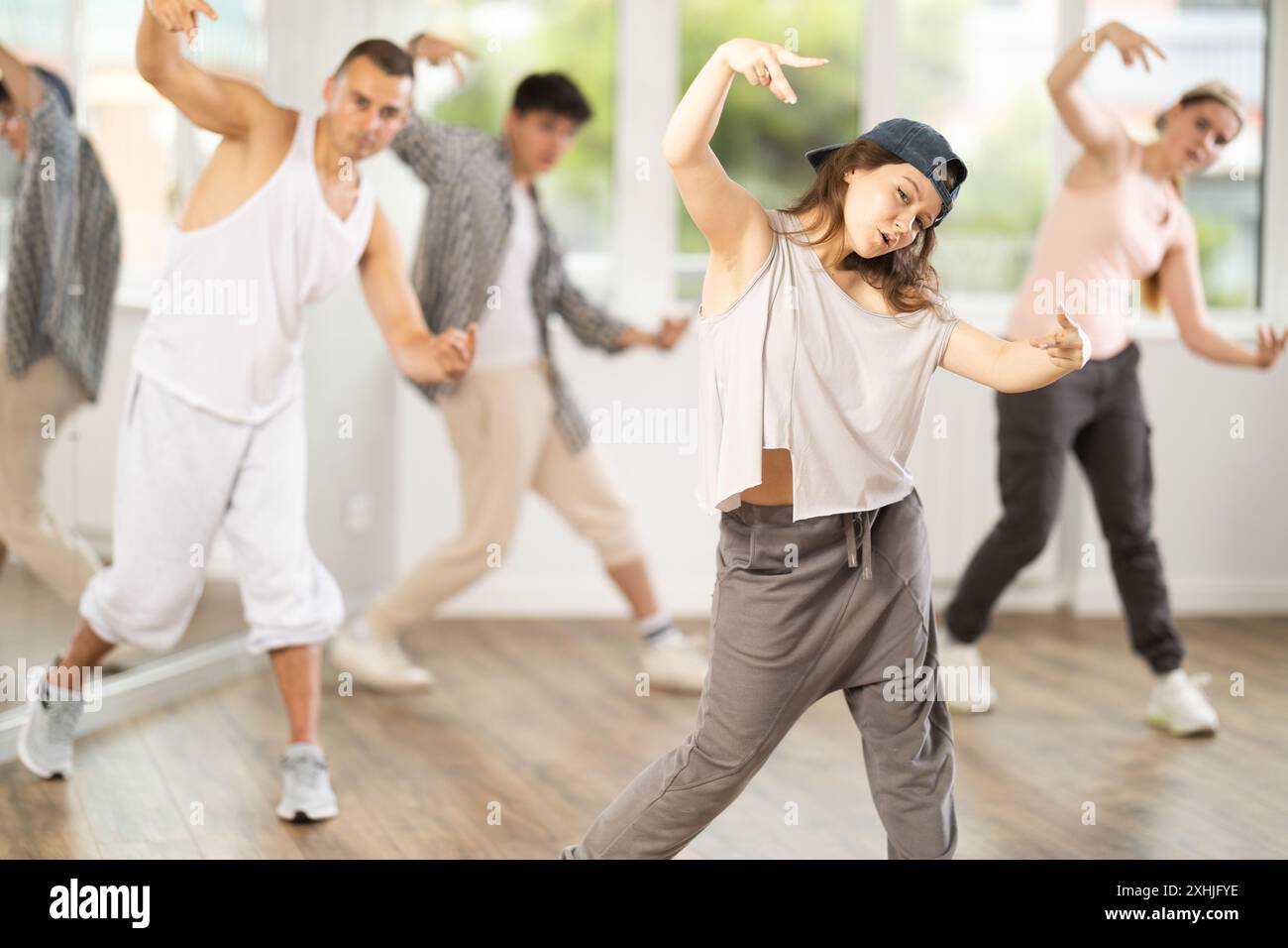 Group of energetic hip hop dancers focused on training while gathered ...