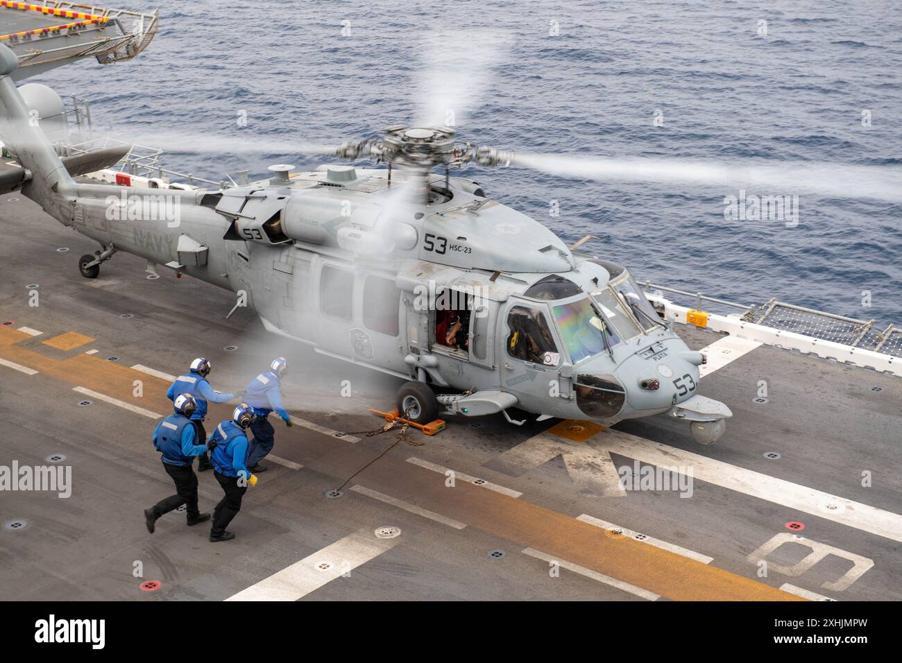 Sailors assigned to USS Boxer (LHD 4) remove the chock and chains from ...