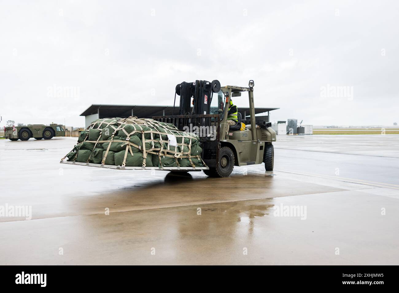 An Australian Public Service defence employee operates a forklift to ...