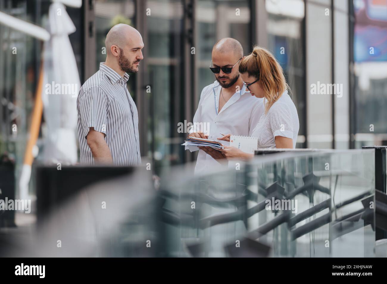 Group of business colleagues discussing work outdoors in a modern urban ...