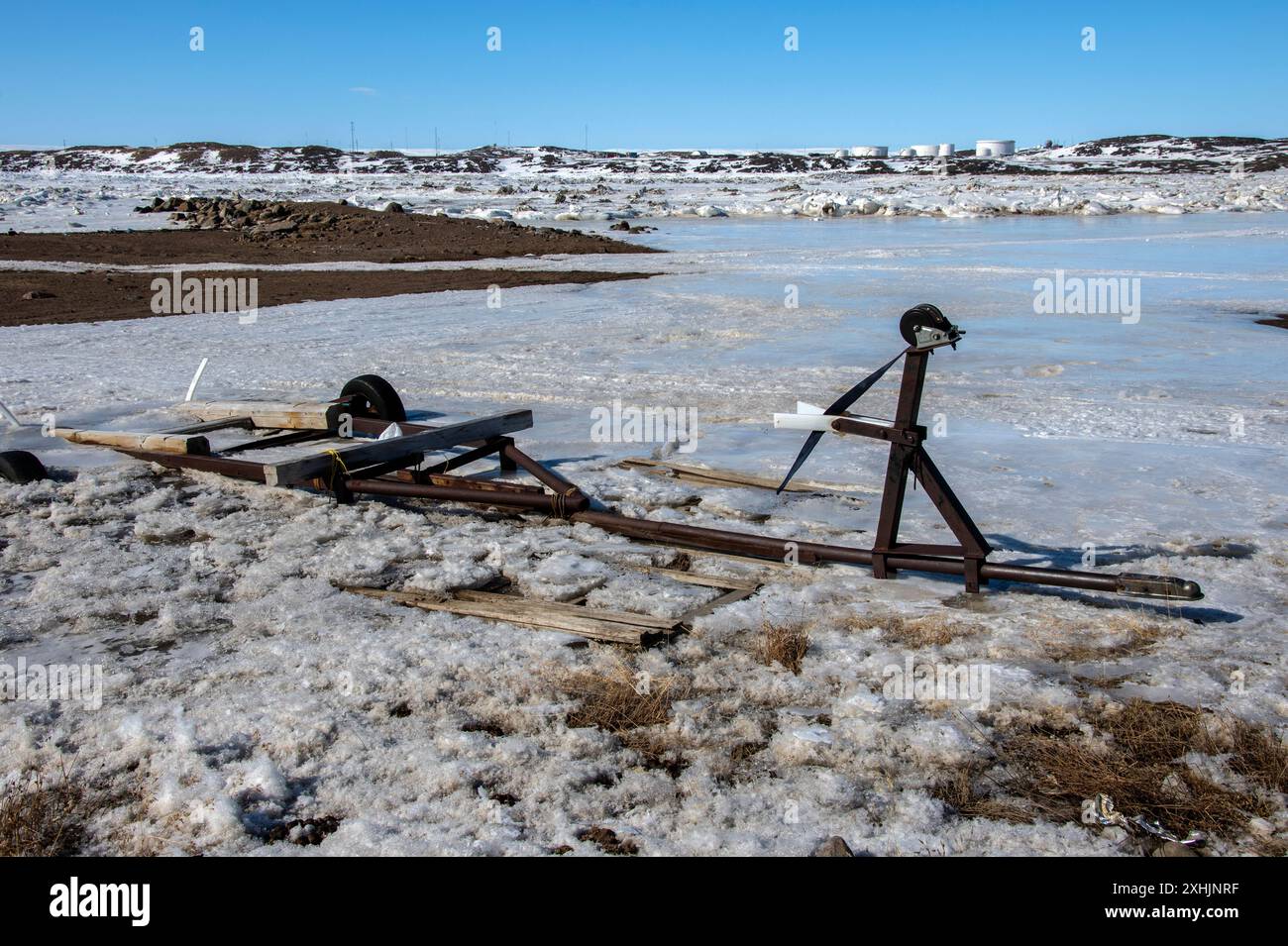 Boat trailer frozen in the ice on the beach on Frobisher Bay in Iqaluit, Nunavut, Canada Stock ...