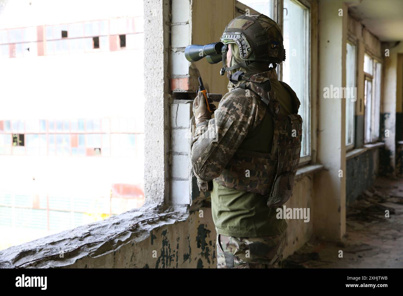 Military mission. Soldier in uniform with binoculars inside abandoned ...