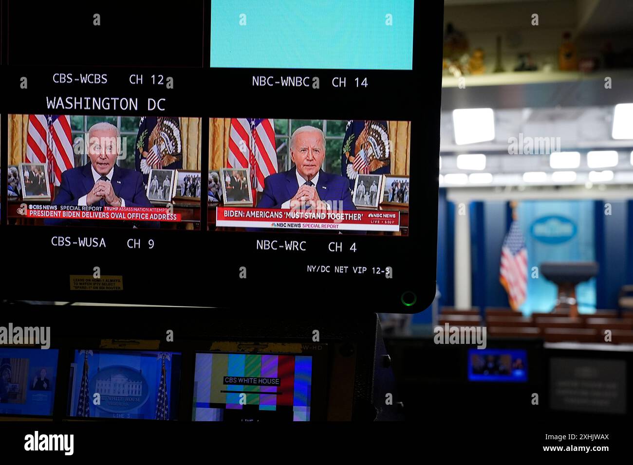 President Joe Biden can be seen on monitors in the press briefing room ...