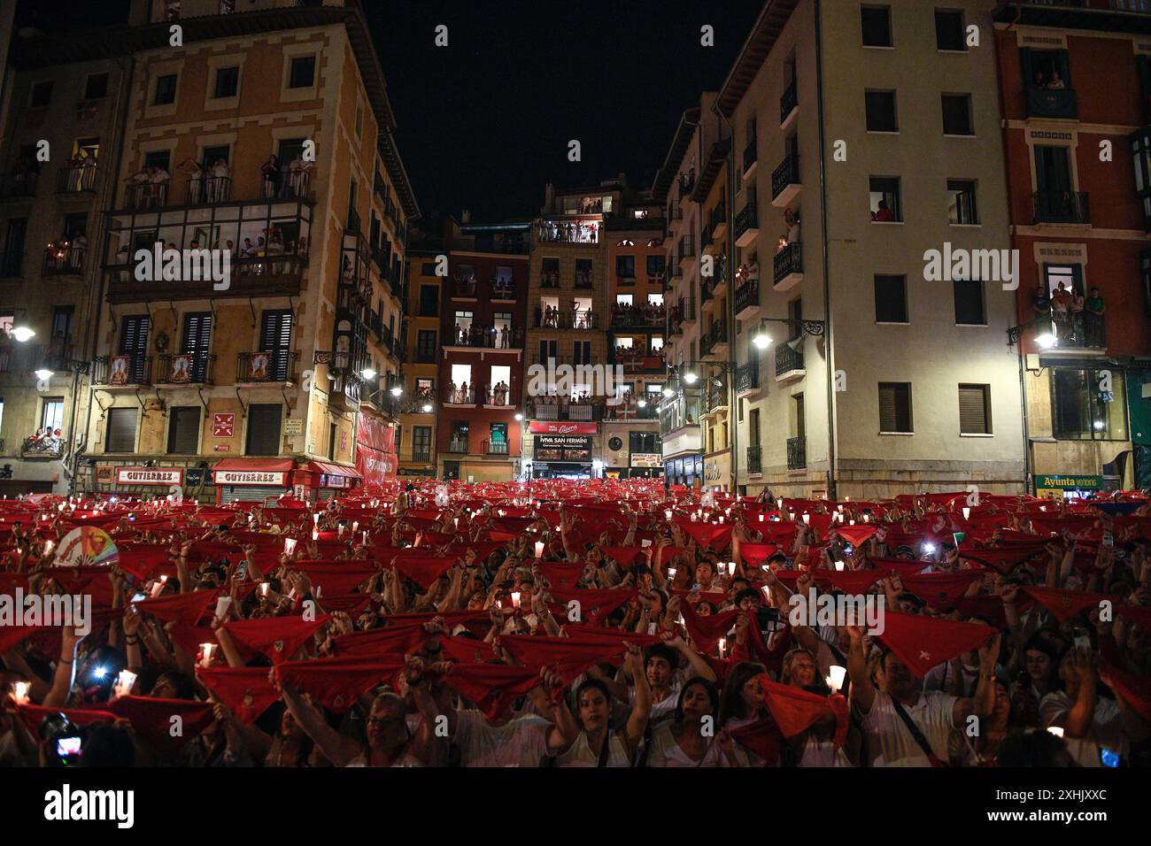 Pamplona, 14 july ,2024. Revellers hold up red scarves and candles as ...