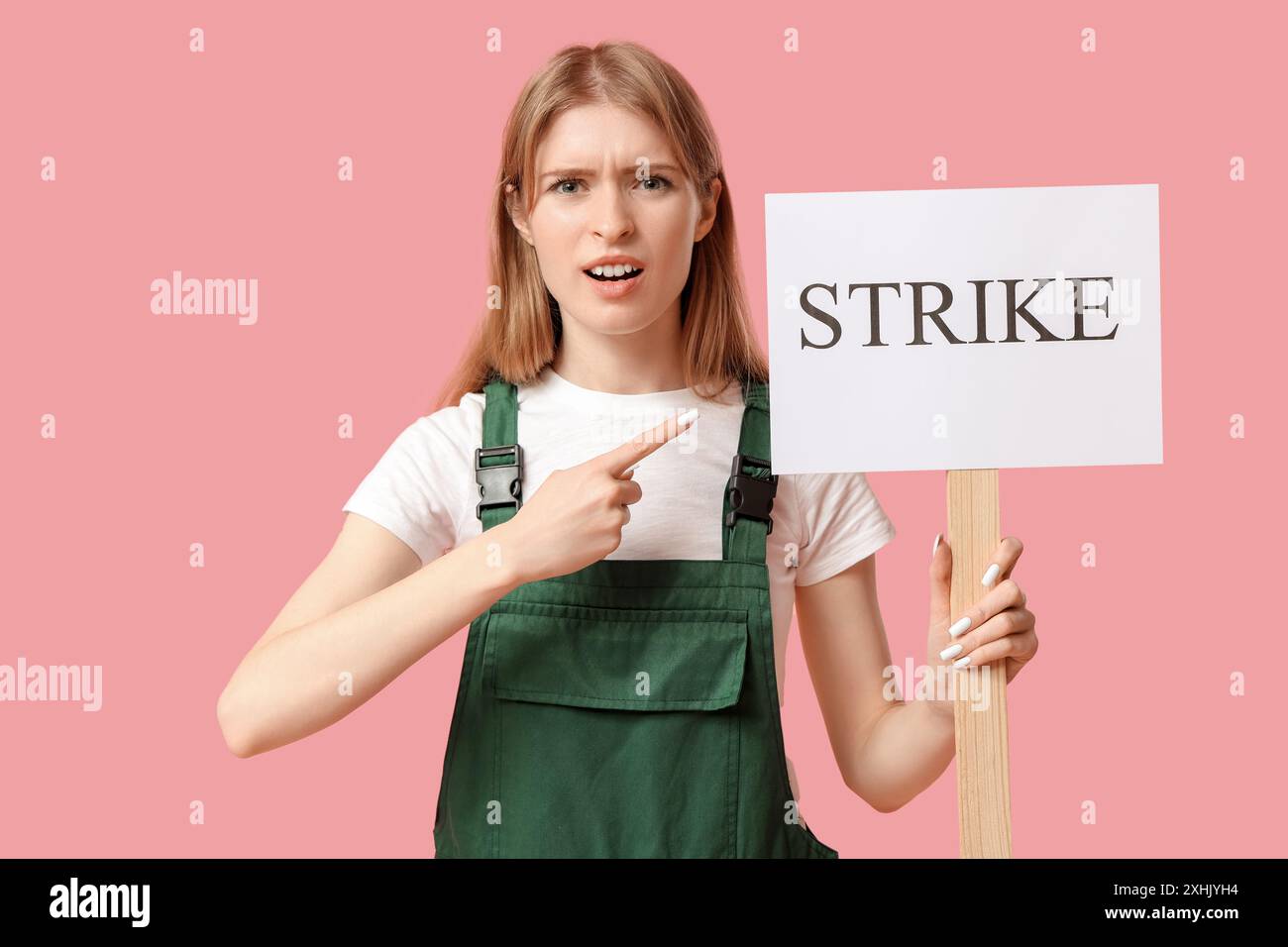 Protesting female construction worker holding placard with text STRIKE ...