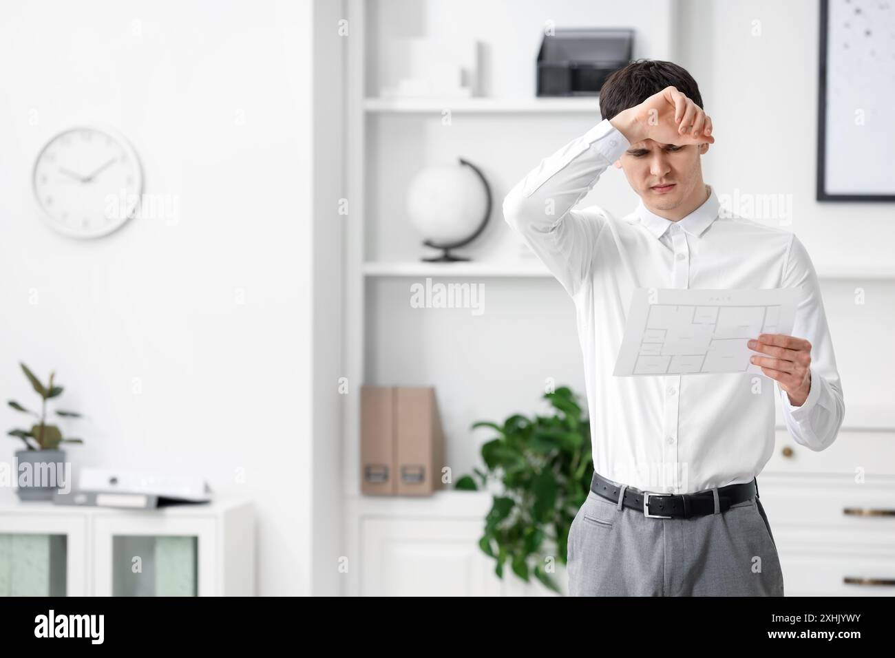 Embarrassed man with document in office, space for text Stock Photo - Alamy