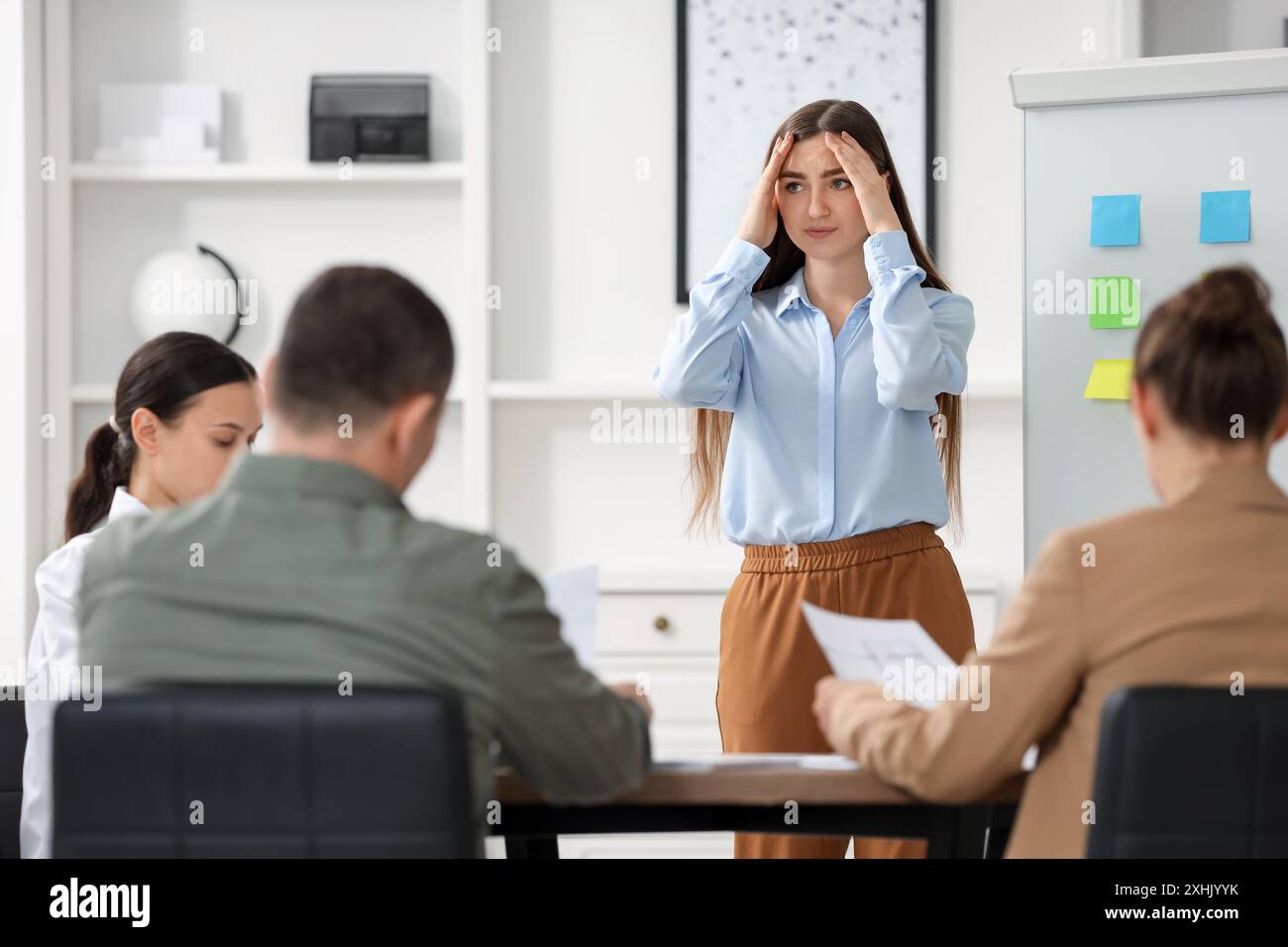 Woman feeling embarrassed during business meeting in office Stock Photo ...