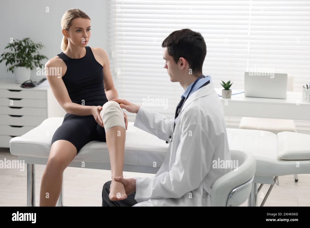 Sports injury. Doctor examining patient's knee in hospital Stock Photo ...