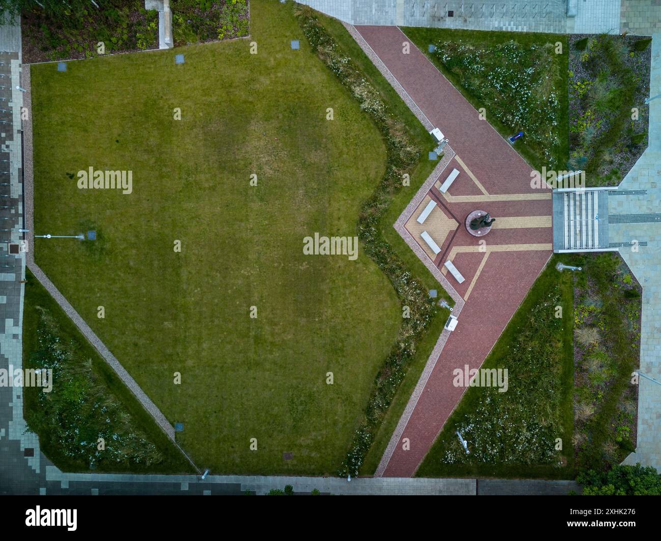 Aerial view of a city park featuring a large green square of grass ...
