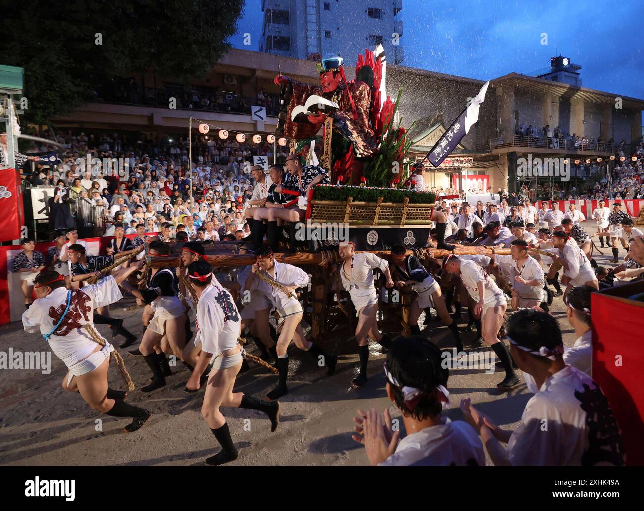 In heavy rain, participants carrying the Yamakasa float arrive at ...