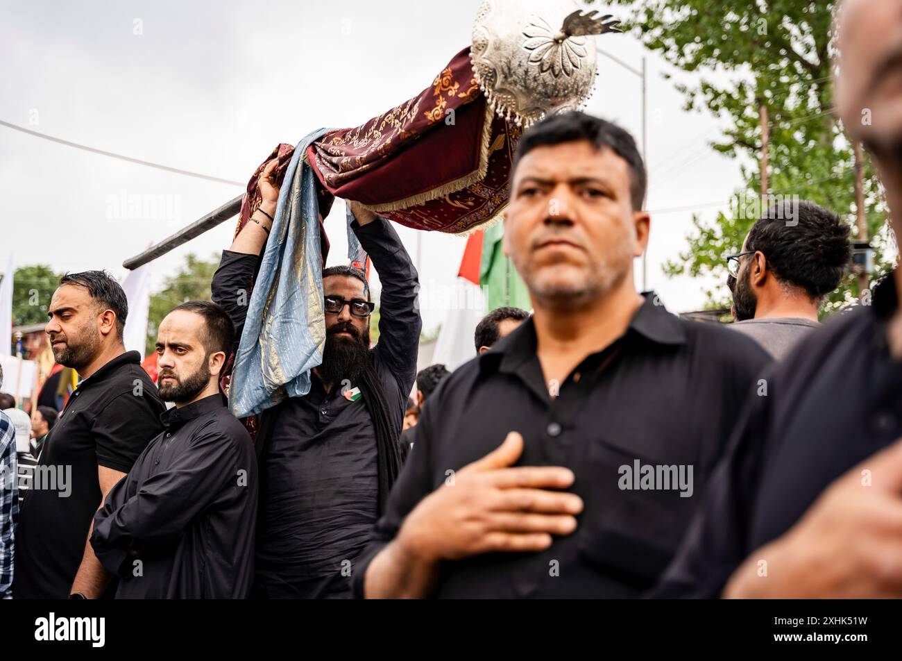 Srinagar, India. 14th July, 2024. A Kashmiri Shia Muslim man walks with ...