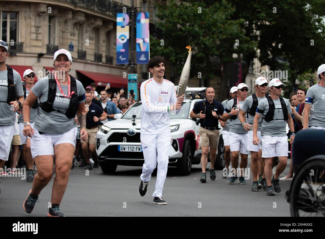 Paris, France. 14th July, 2024. A torch bearer runs the Olympic Torch ...