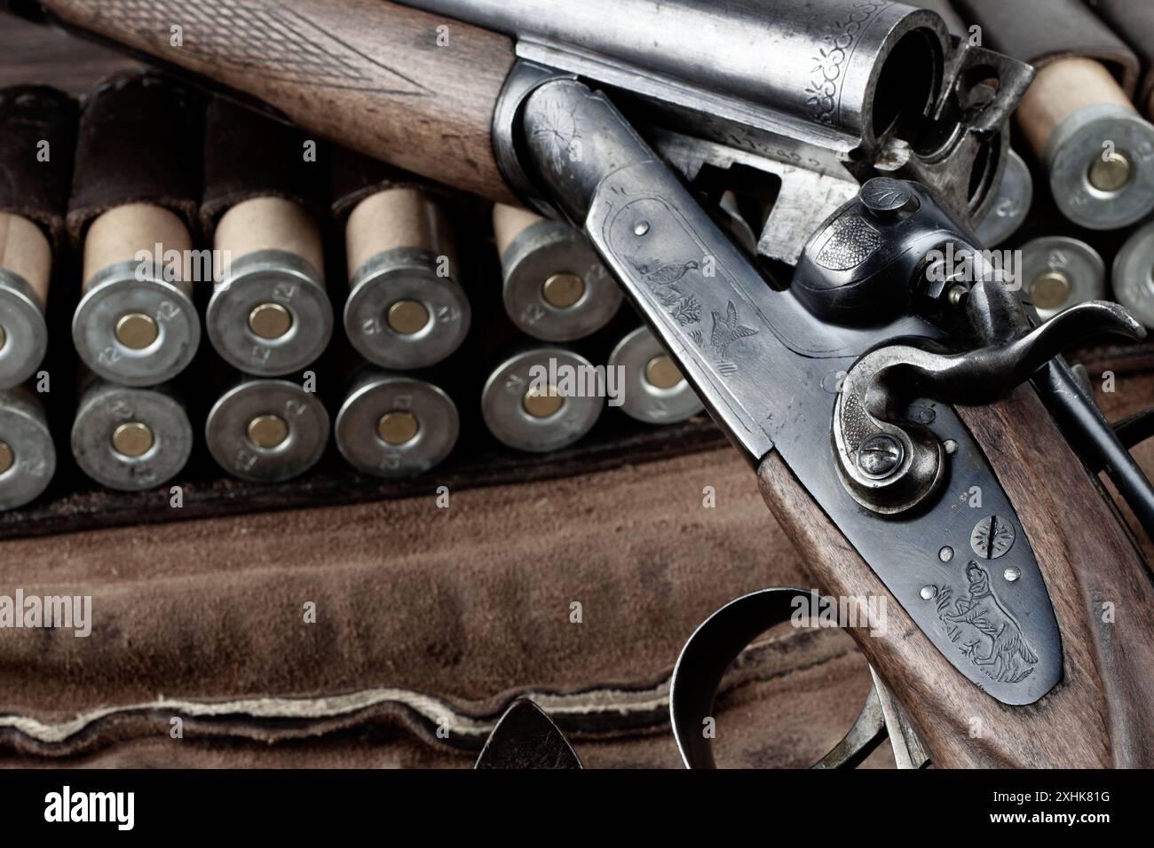 double barreled side shotgun with cartridges in bandolier on wooden ...