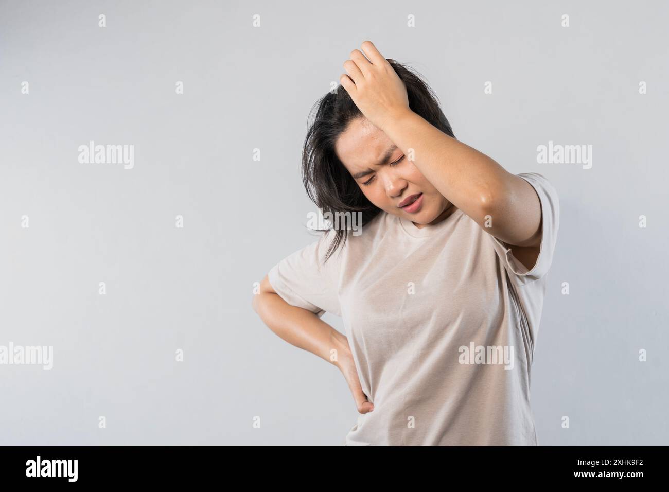 Frustrated asian woman holds hands on head, has headache, looks ...