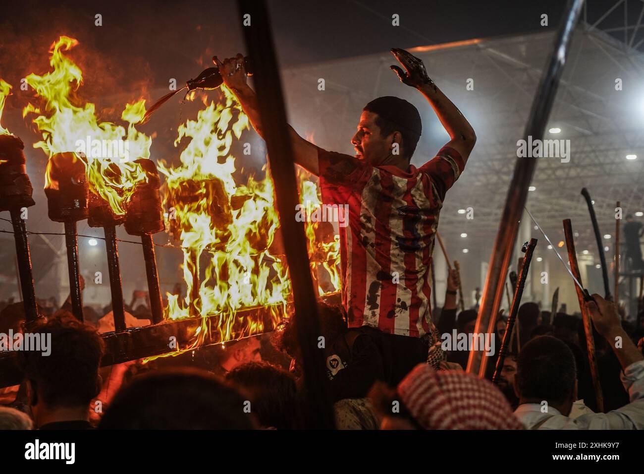 Najaf, Iraq. 14th July, 2024. A Shiite Muslim lights a torch as he ...