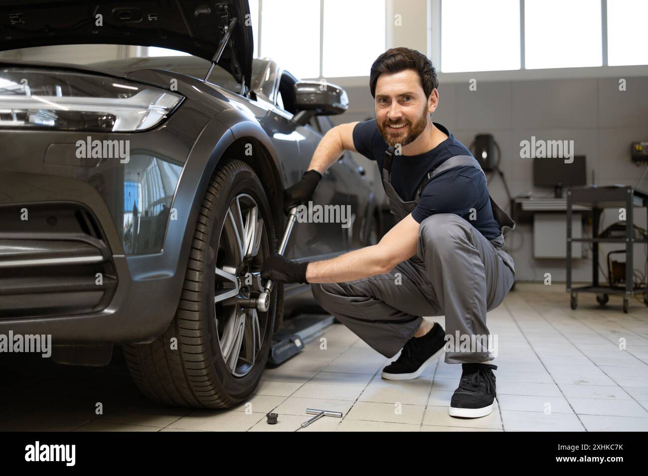 Mechanic working on car wheel in auto repair shop Stock Photo - Alamy