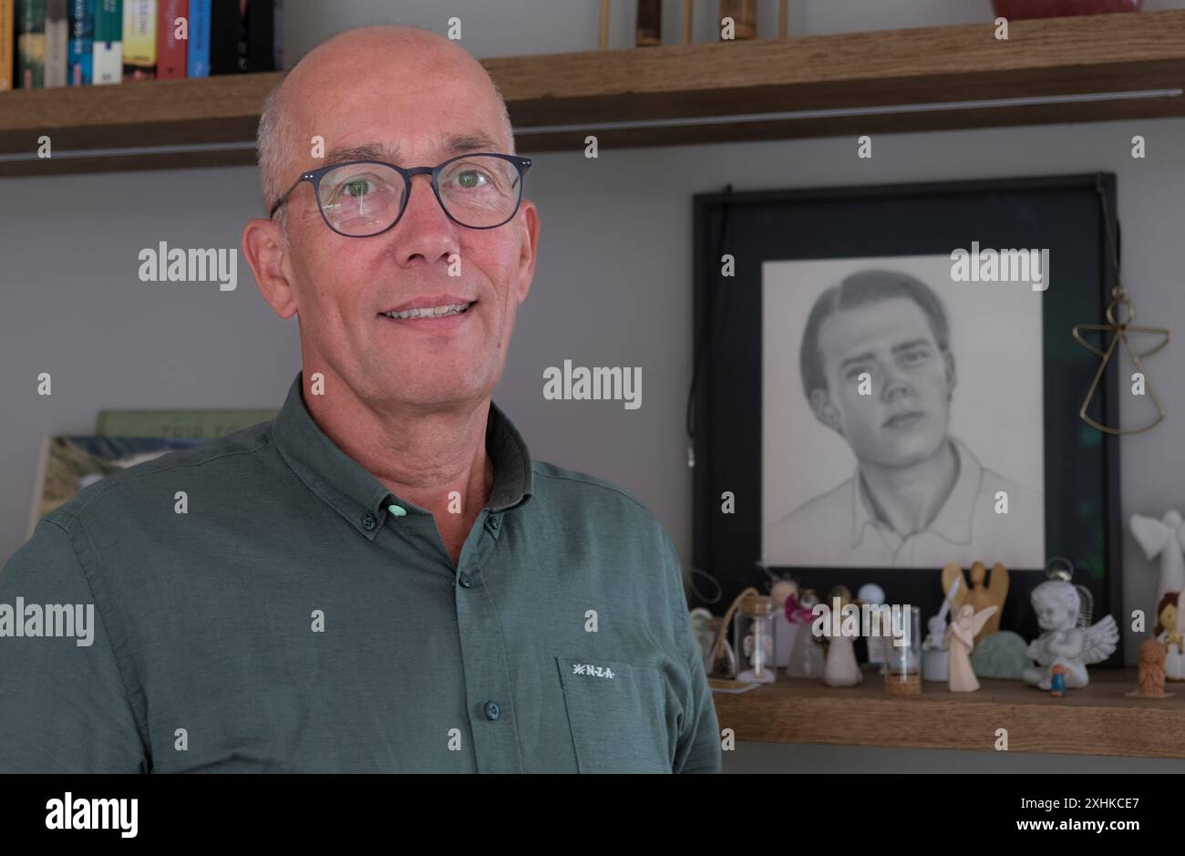 Thomas Schansman poses in front of a drawing of his son, Quinn, at his ...