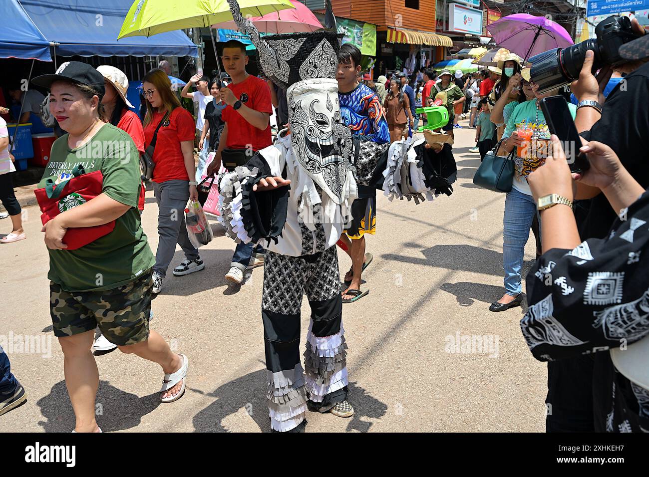 A masked 'ghost' in patchwork costume posing for pictures at the Phi Ta ...