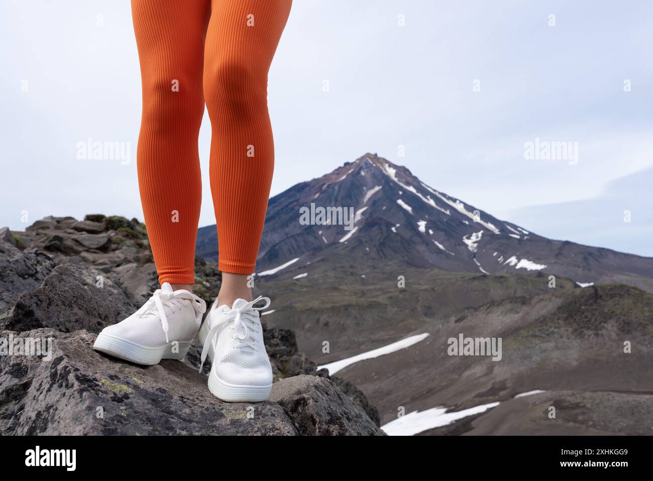 Athletic female model in orange fitness leggings and white trainers ...