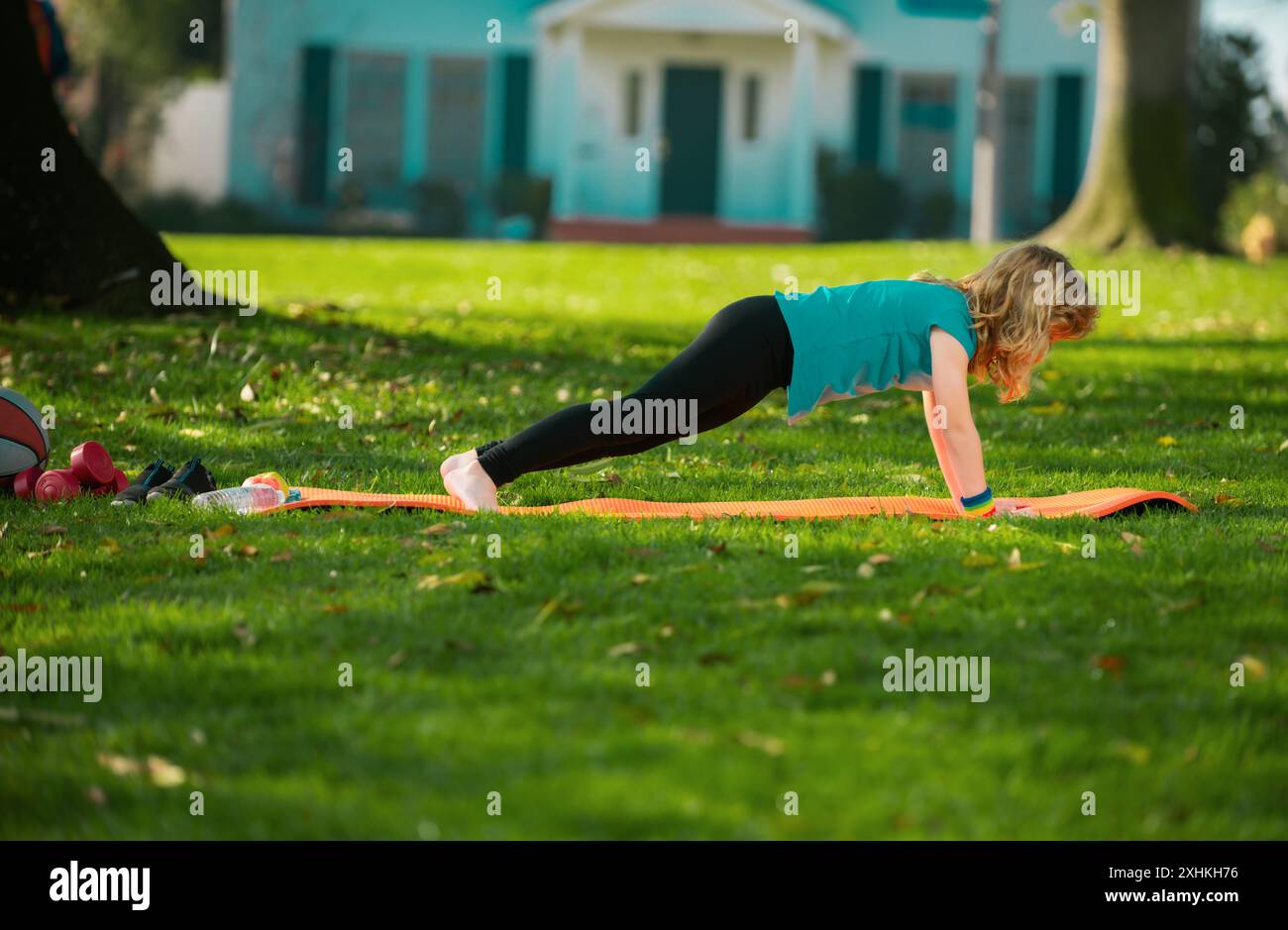 Sport kids. Child is pushing up on the green grass. Boy doing push-ups ...