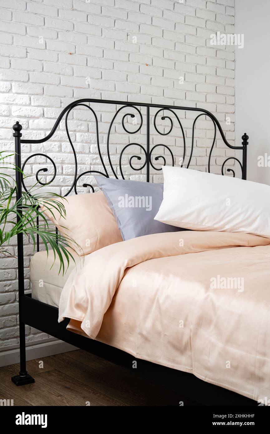 Peach Colored Bedding on a Black Wrought Iron Bed Frame Stock Photo - Alamy