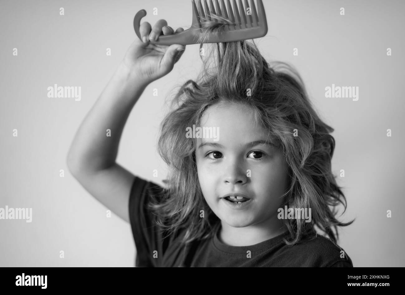 Daily hair care routine. Little kid combing hair, isolated studio ...
