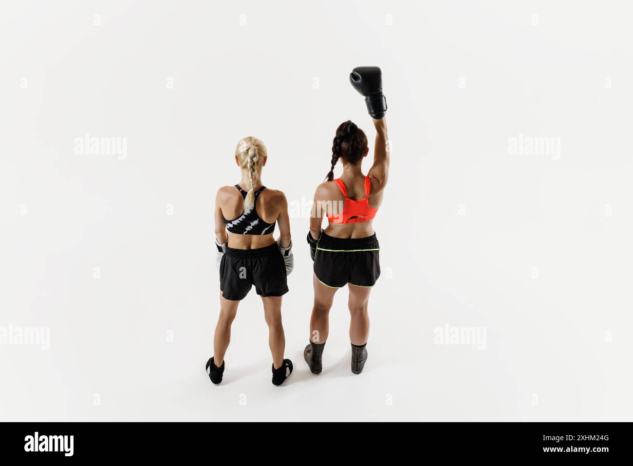 Victorious female boxer raising hand in glove in triumph isolated on ...