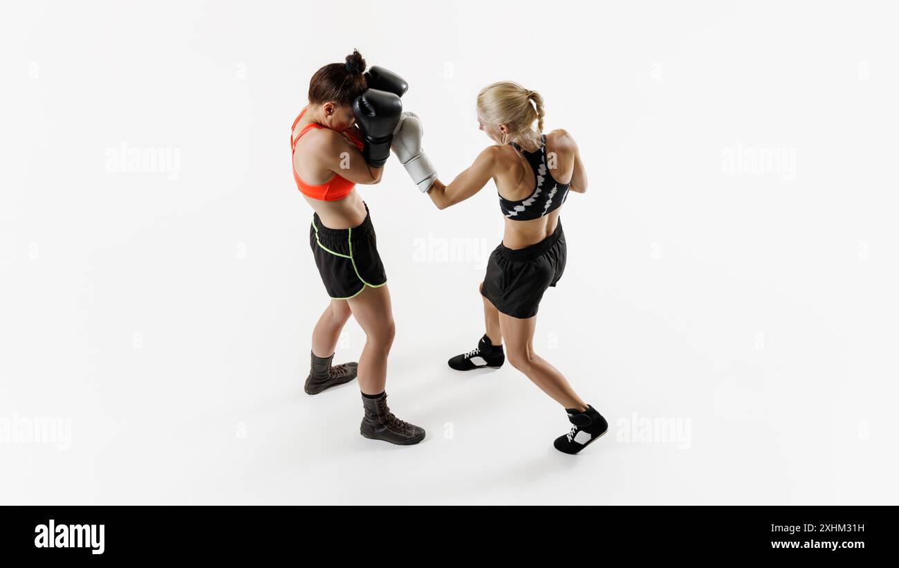 Overhead shot of two women engaging in competitive boxing session ...