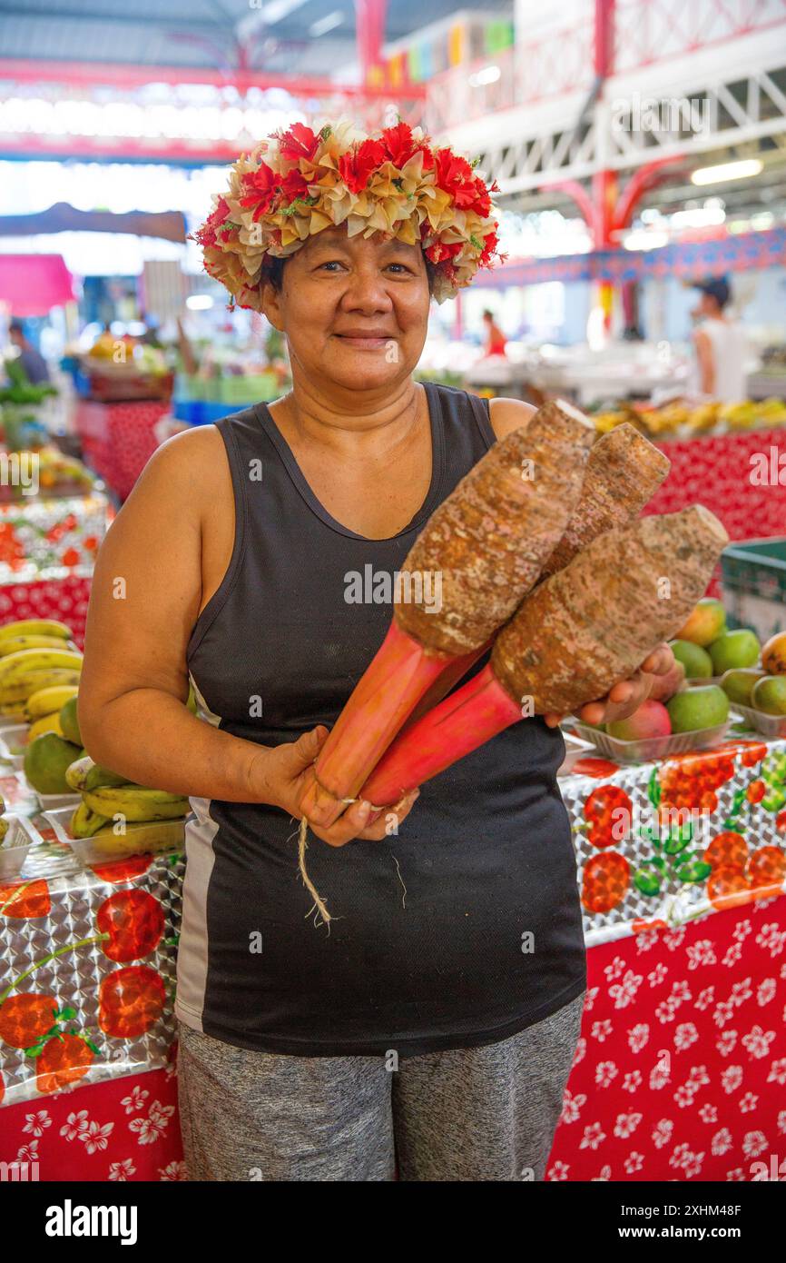French Polynesia, Tahiti island, Papeete, Polynesian saleswoman with a flower headdress holding ...