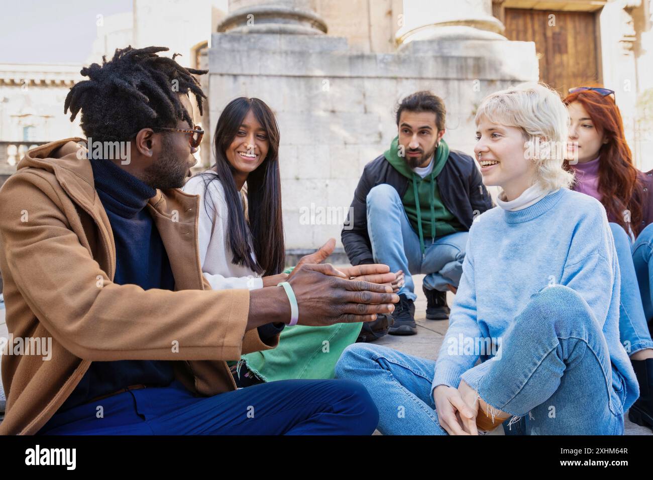 Group of diverse young adults engaging in lively conversation on ...