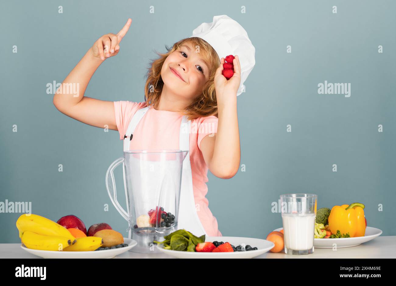 Cooking children. Chef kid boy making fresh raspberry smoothie for ...