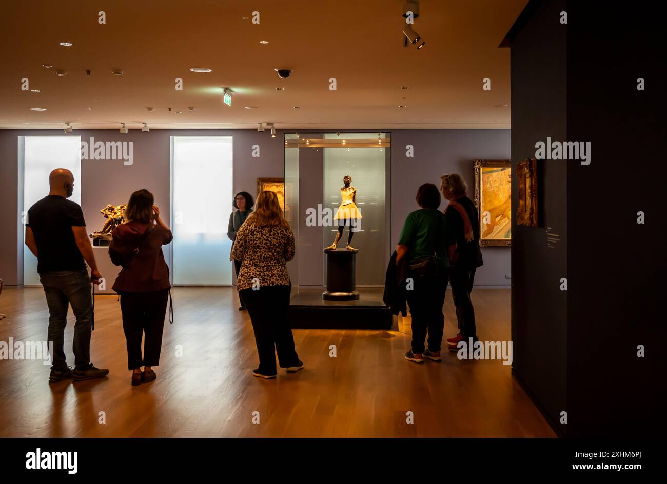 People listening to a guide around Edgar Degas sculpture 'Little Dancer ... People listening to a guide around Edgar Degas sculpture 'Little Dancer ...