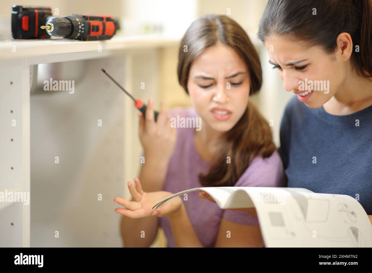 Confused roommates checking furniture installation manual reforming ...