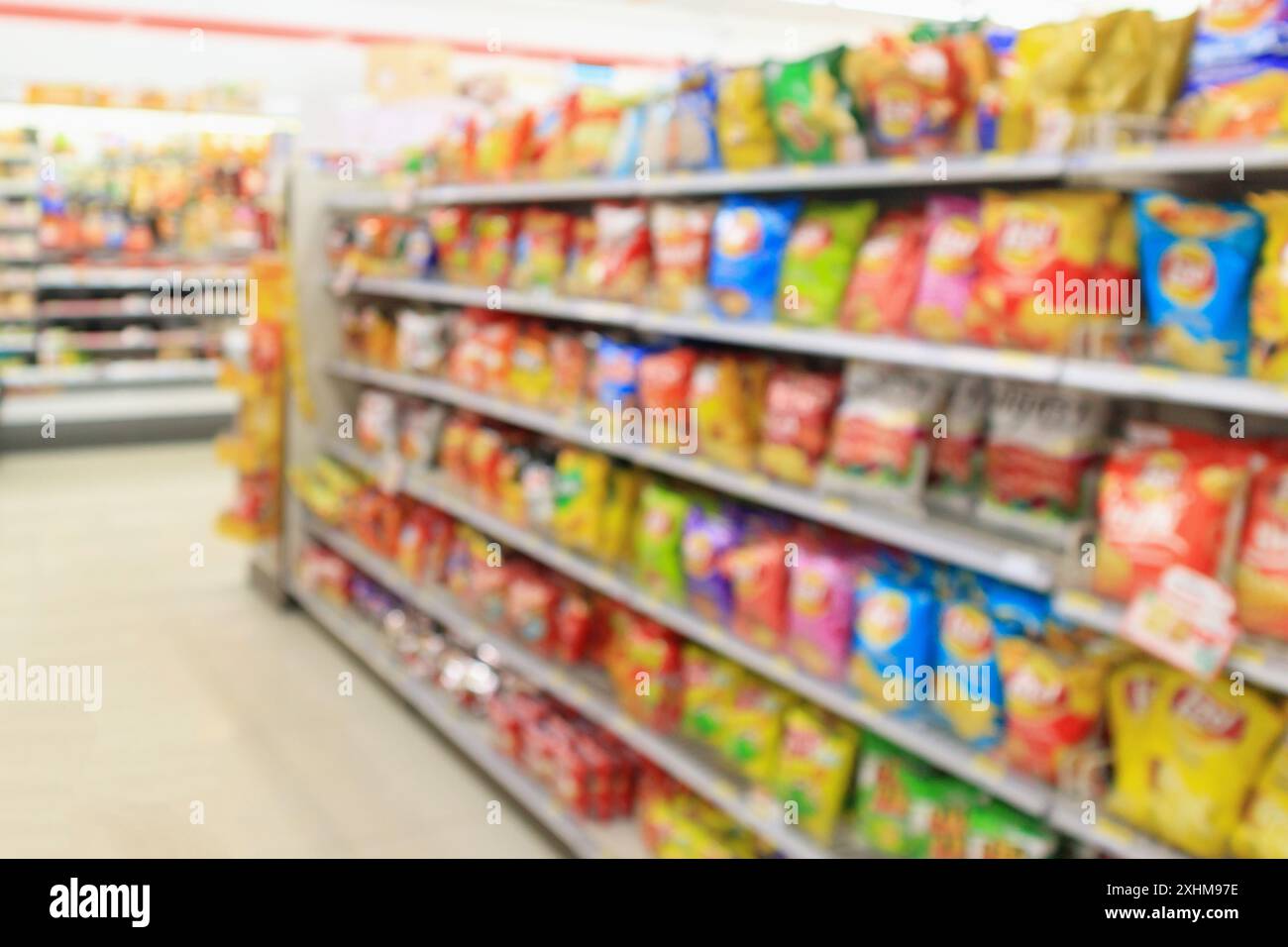 Supermarket convenience store shelves with Potato chips snack blur ...