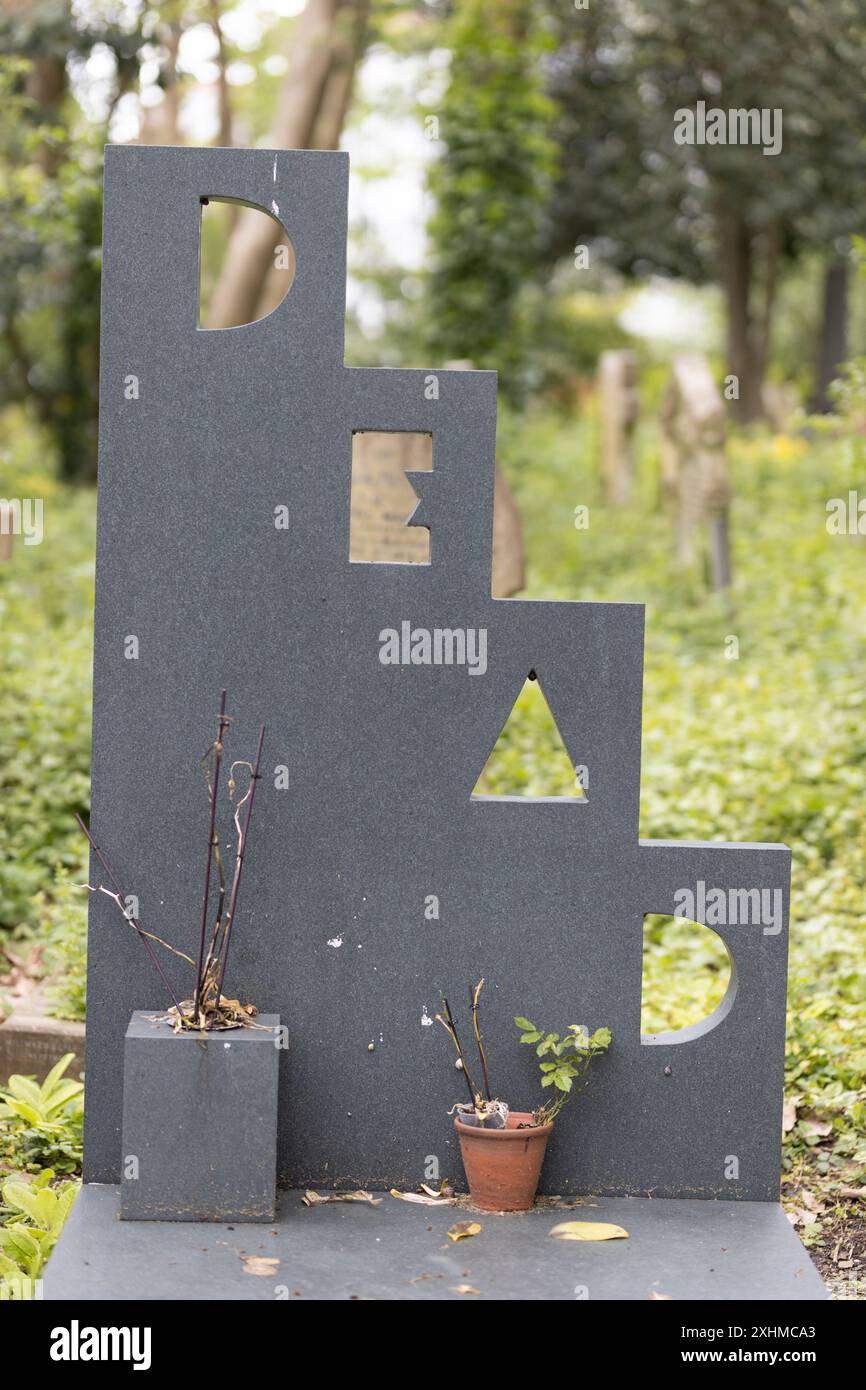 A modern gravestone with an ironic 'DEAD' carved into it. The grave ...