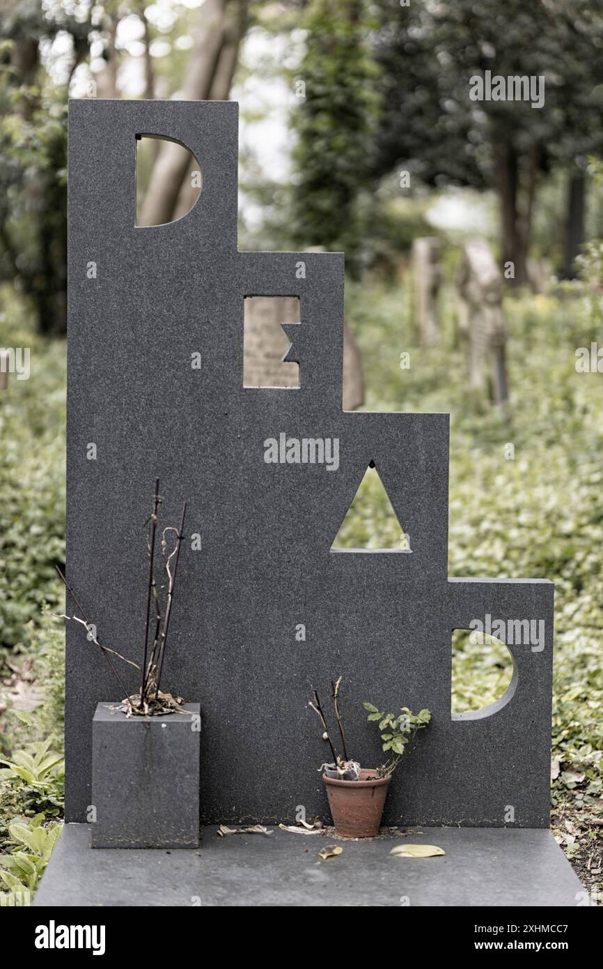 A modern gravestone with an ironic 'DEAD' carved into it. The grave ...