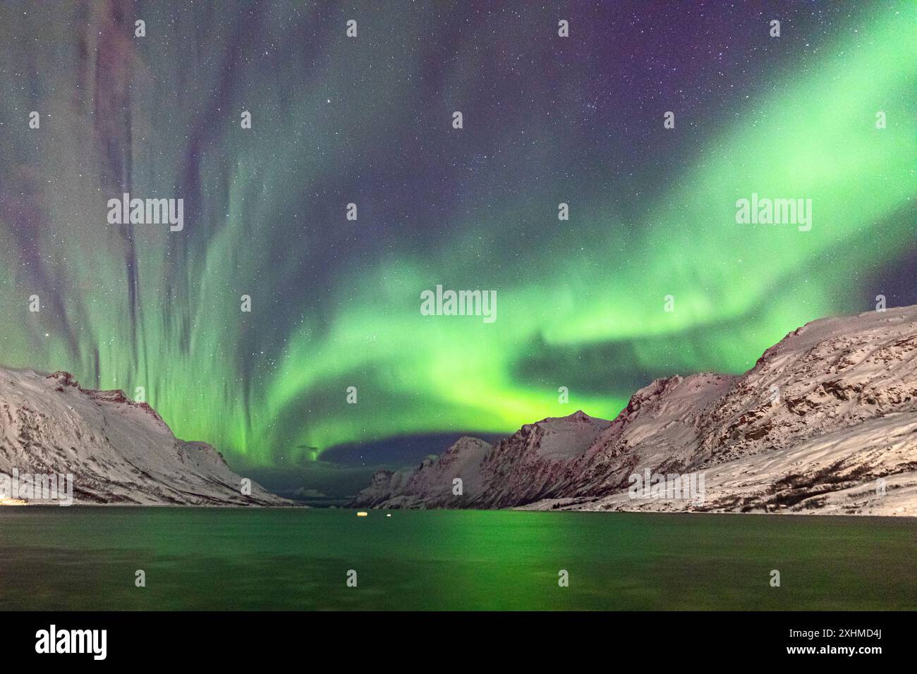 Snowy mountains and fjord under the Aurora Borealis, Norway Stock Photo ...