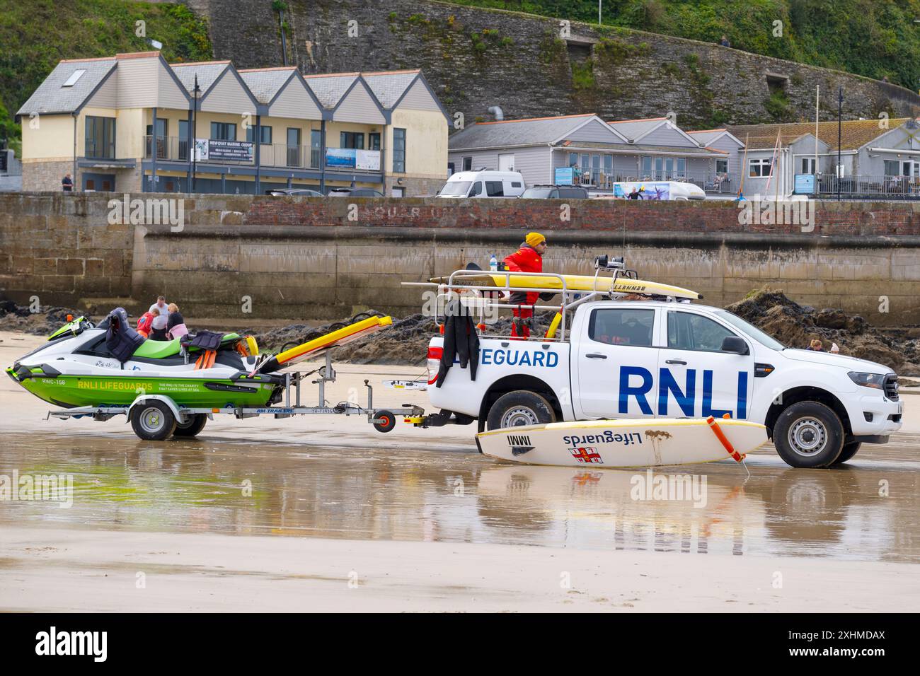 A RNLI lifeguard sitting on an emergency response vehicle truck parked ...