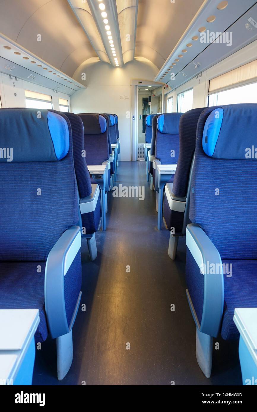Empty modern train with blue seats waiting at the station for ...
