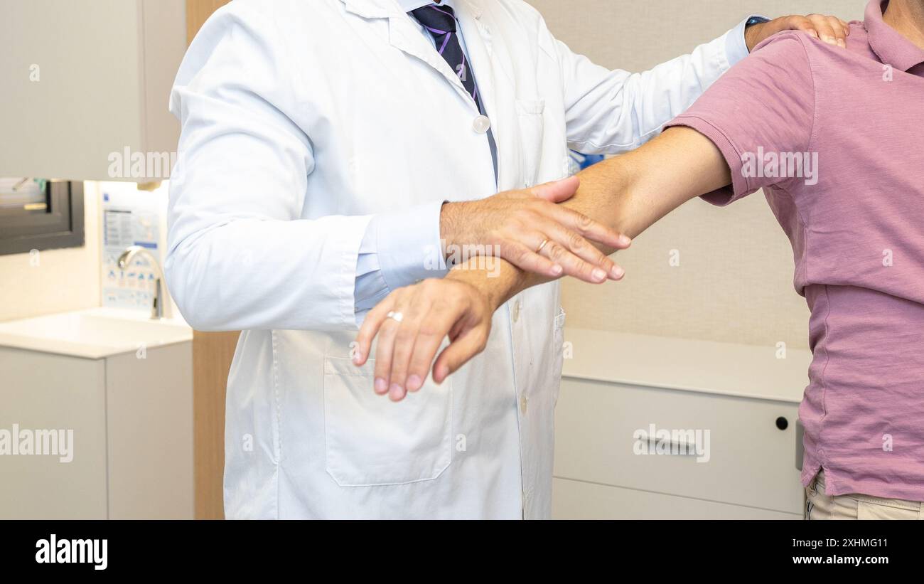 A traumatologist conducting an arm movement test on a patient in a ...