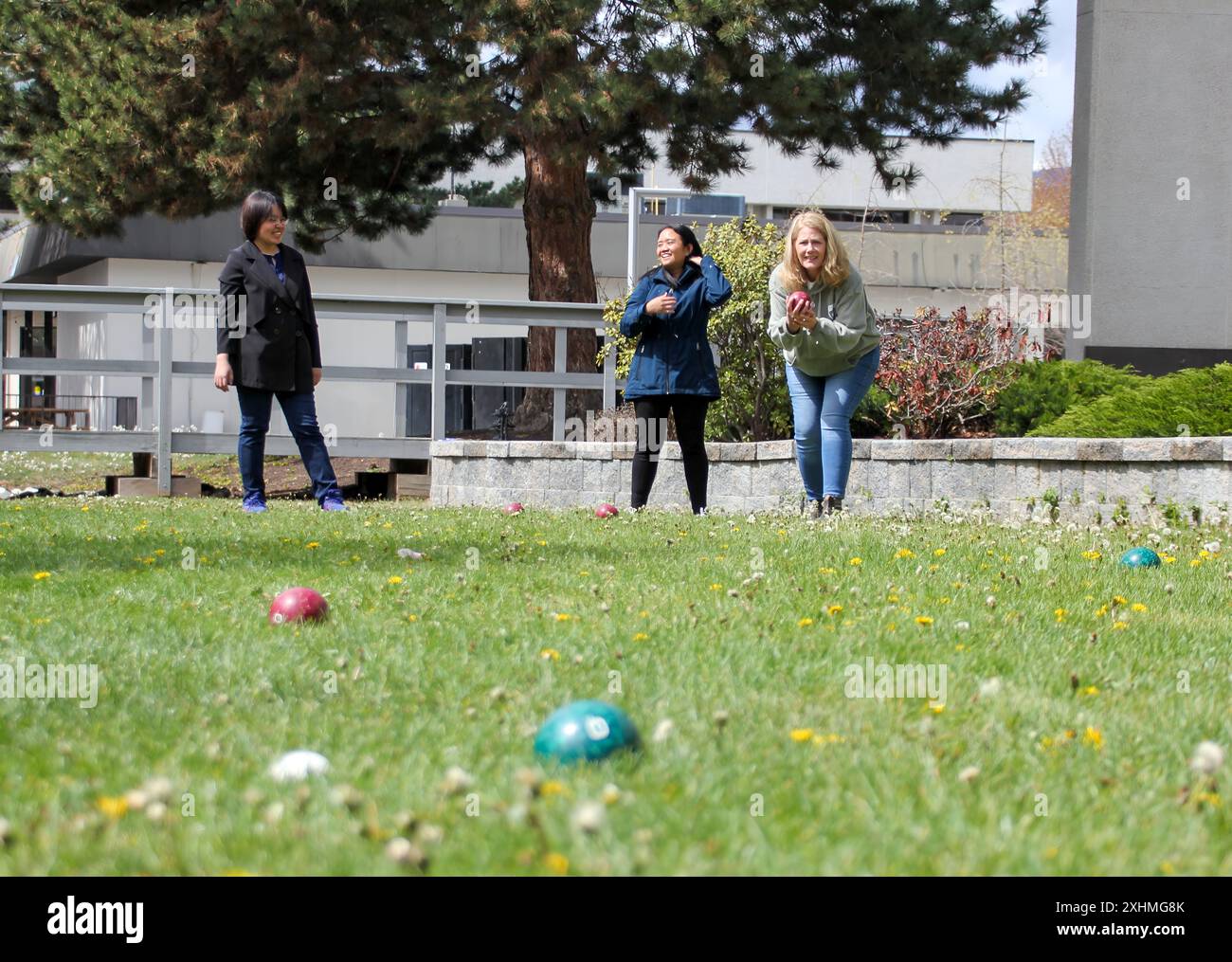 Three women playing bocce ball outdoors on a grassy field Stock Photo ...