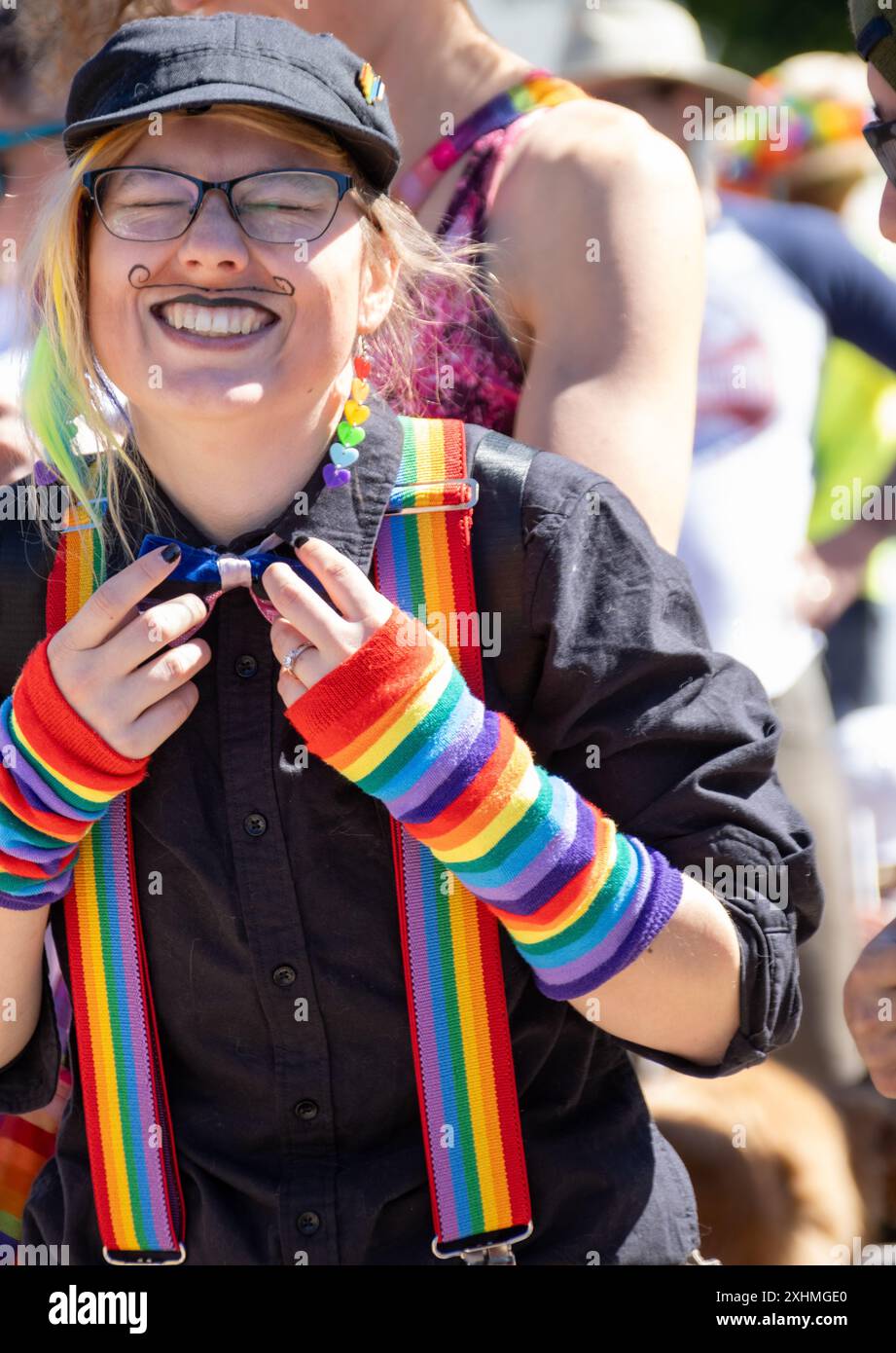 Person smiling at a pride event wearing rainbow accessories Stock Photo ...