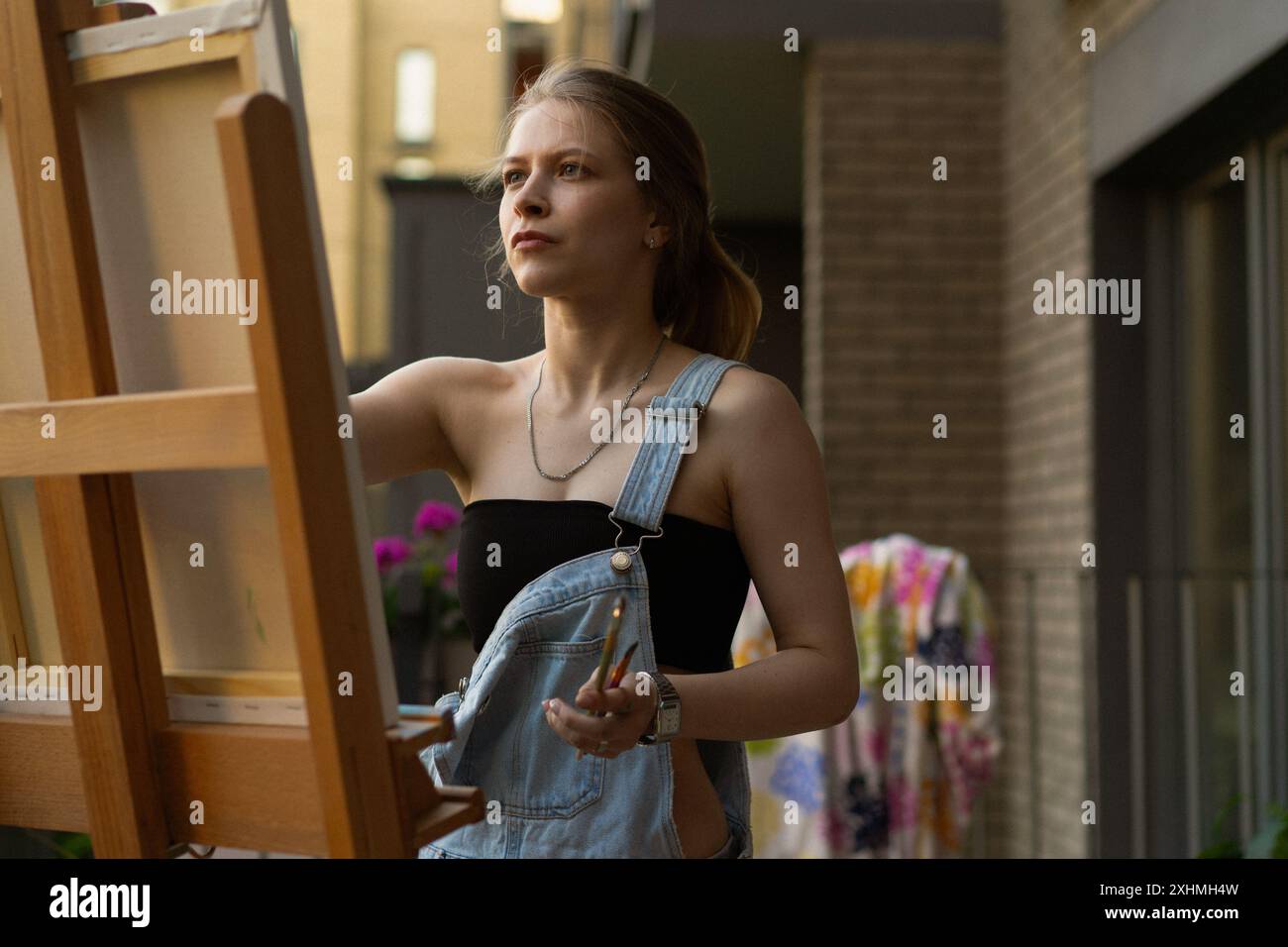 Artist woman painting on canvas at sunset. Natural light Stock Photo ...