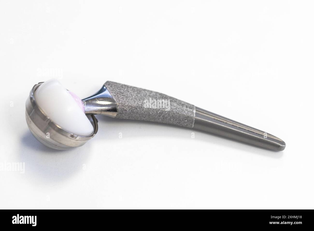 Close-up of a metal hip joint prosthesis on a white background ...