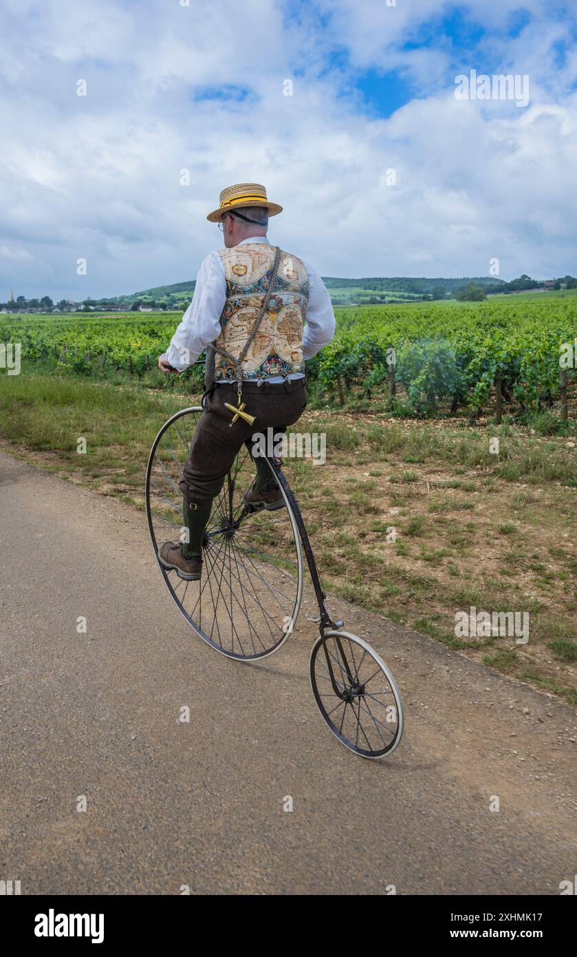 Penny-farthing cyclist in traditional costume riding through the ...