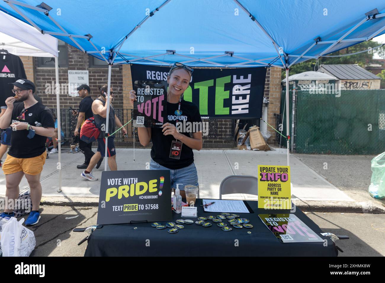 A young woman promoting voter registration at a booth during an outdoor ...