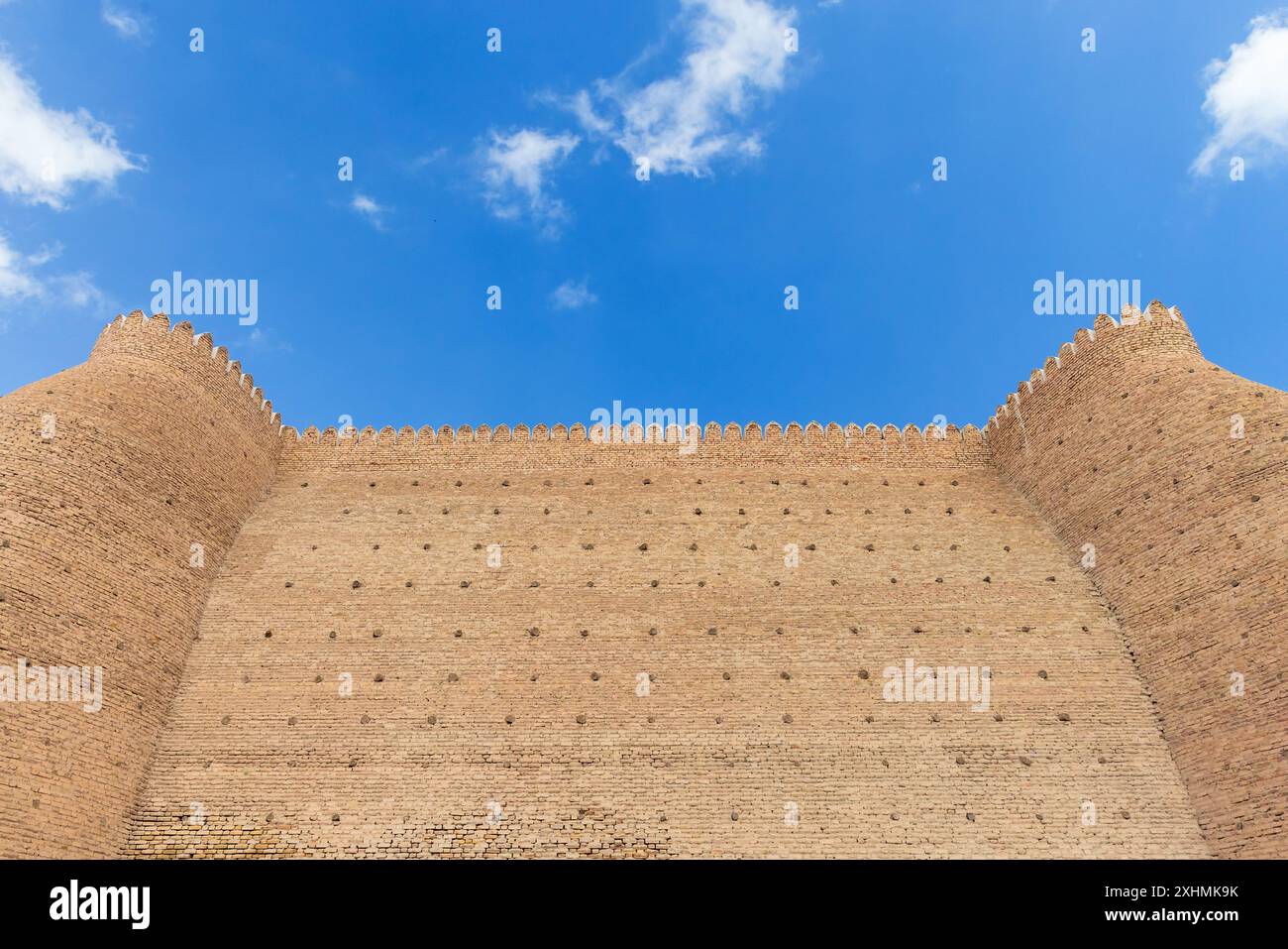 Wall of the Ark of Bukhara is under blue cloudy sky on a sunny summer ...
