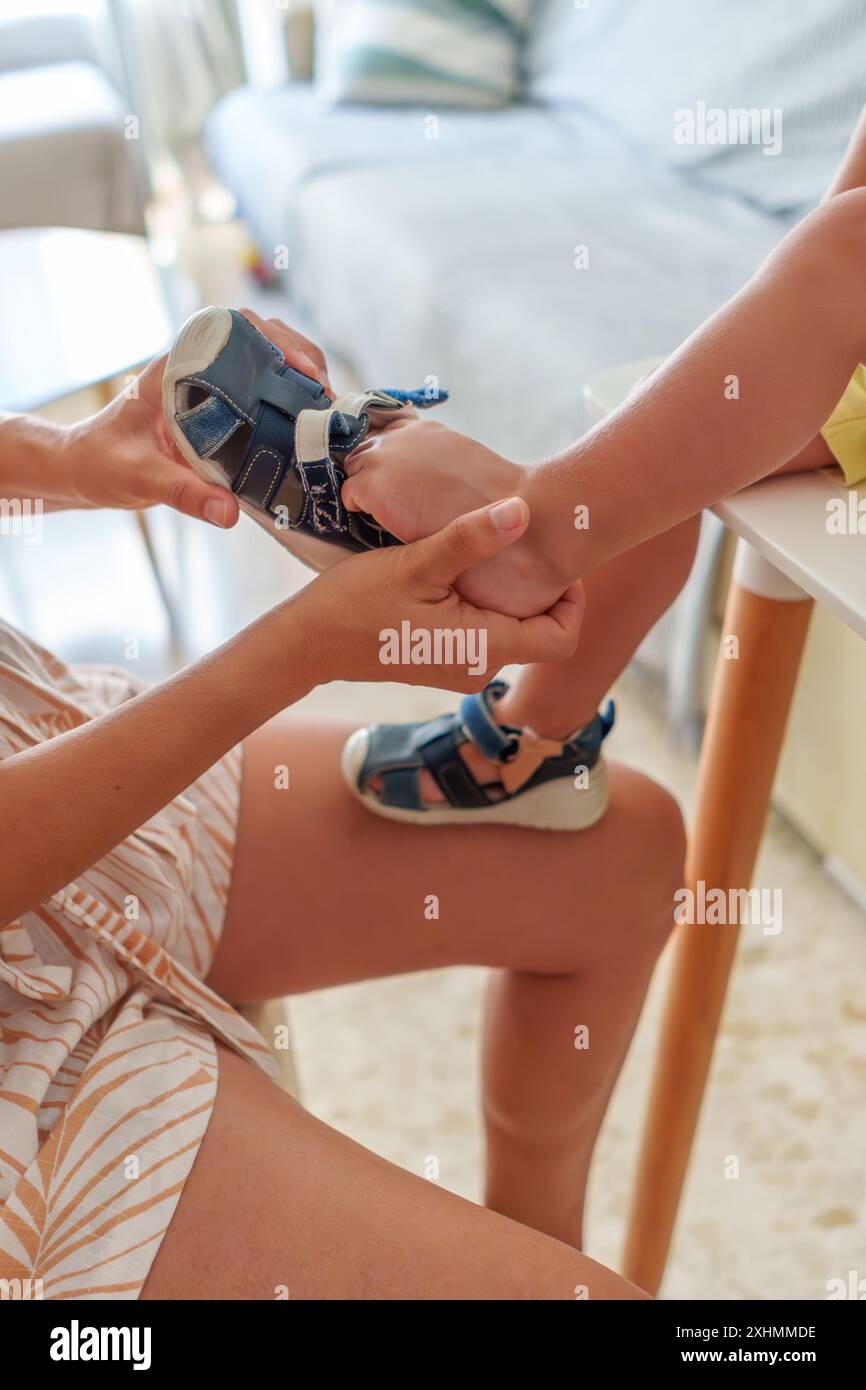 Mother, child and shoes in preparation for school, learning or ...