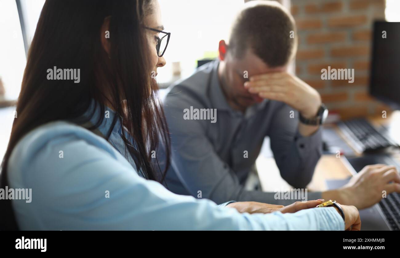 Businesswoman pointing at time to latecomer colleague Stock Photo - Alamy