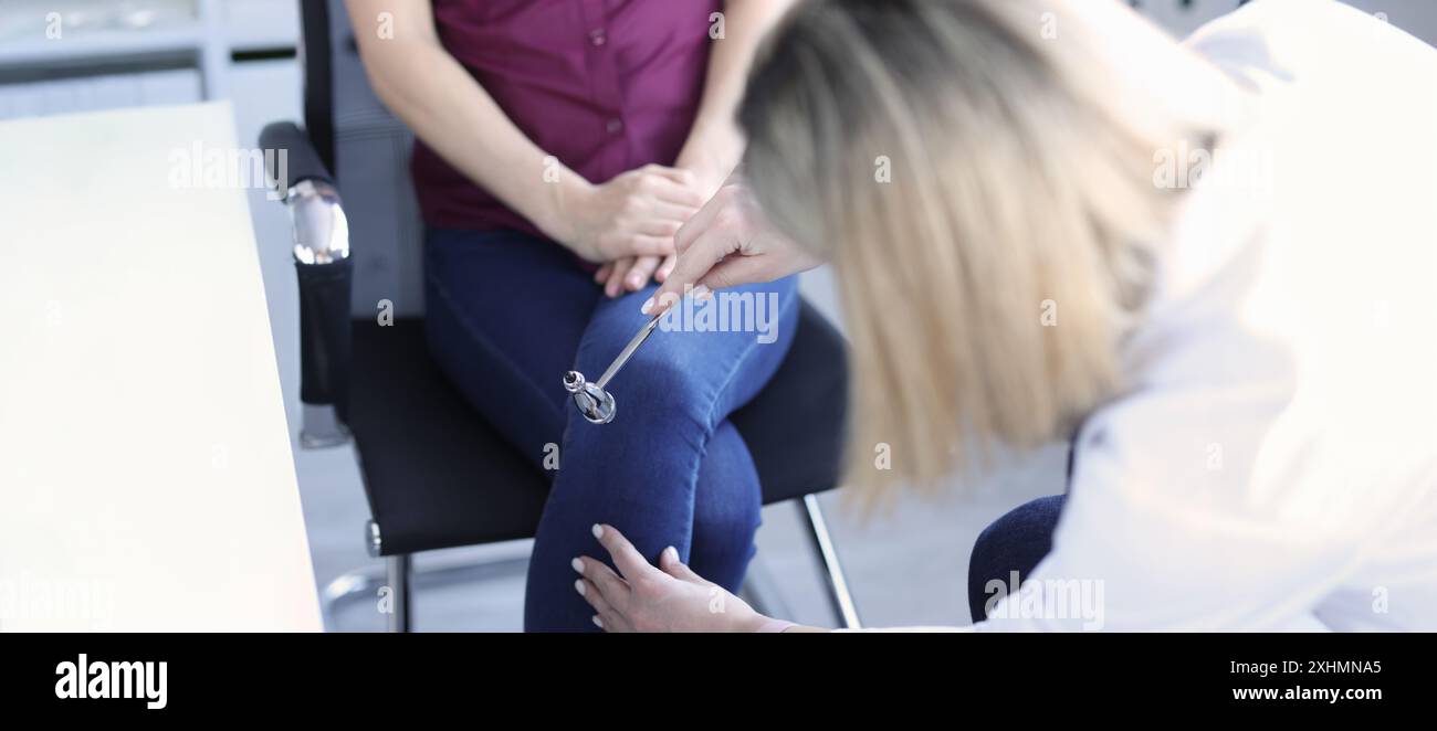 Doctor neurologist checking knee reflexes of female patient using ...